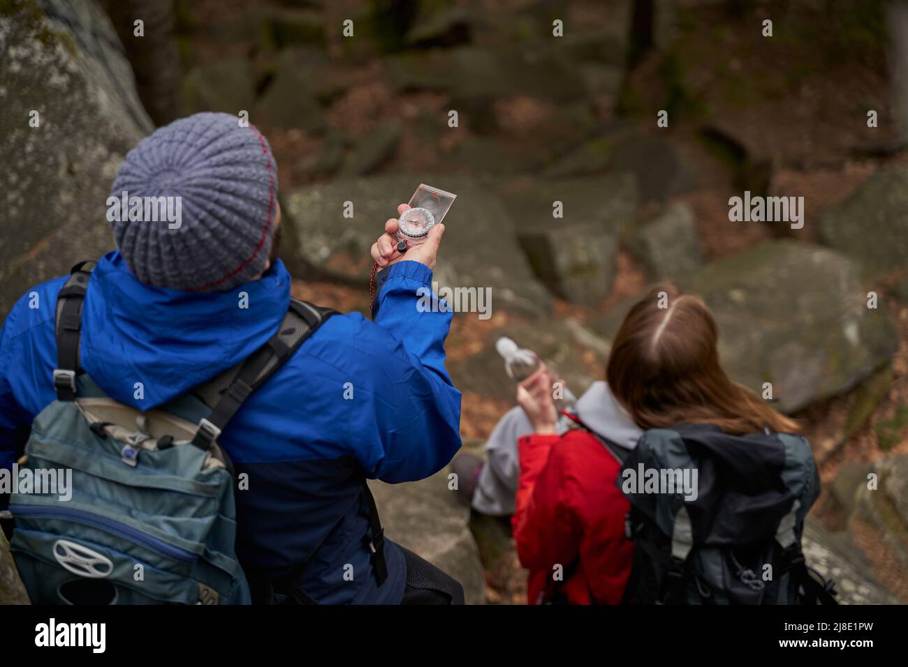 Two hikers determining location in woods with compass Stock Photo - Alamy