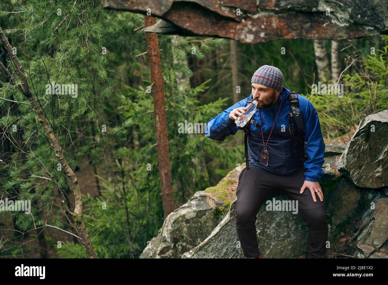 Trekker making a gulp of water while sitting in nature Stock Photo - Alamy