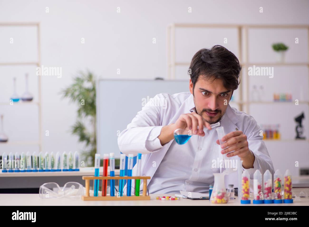 Young chemist in drugs synthesis concept Stock Photo - Alamy