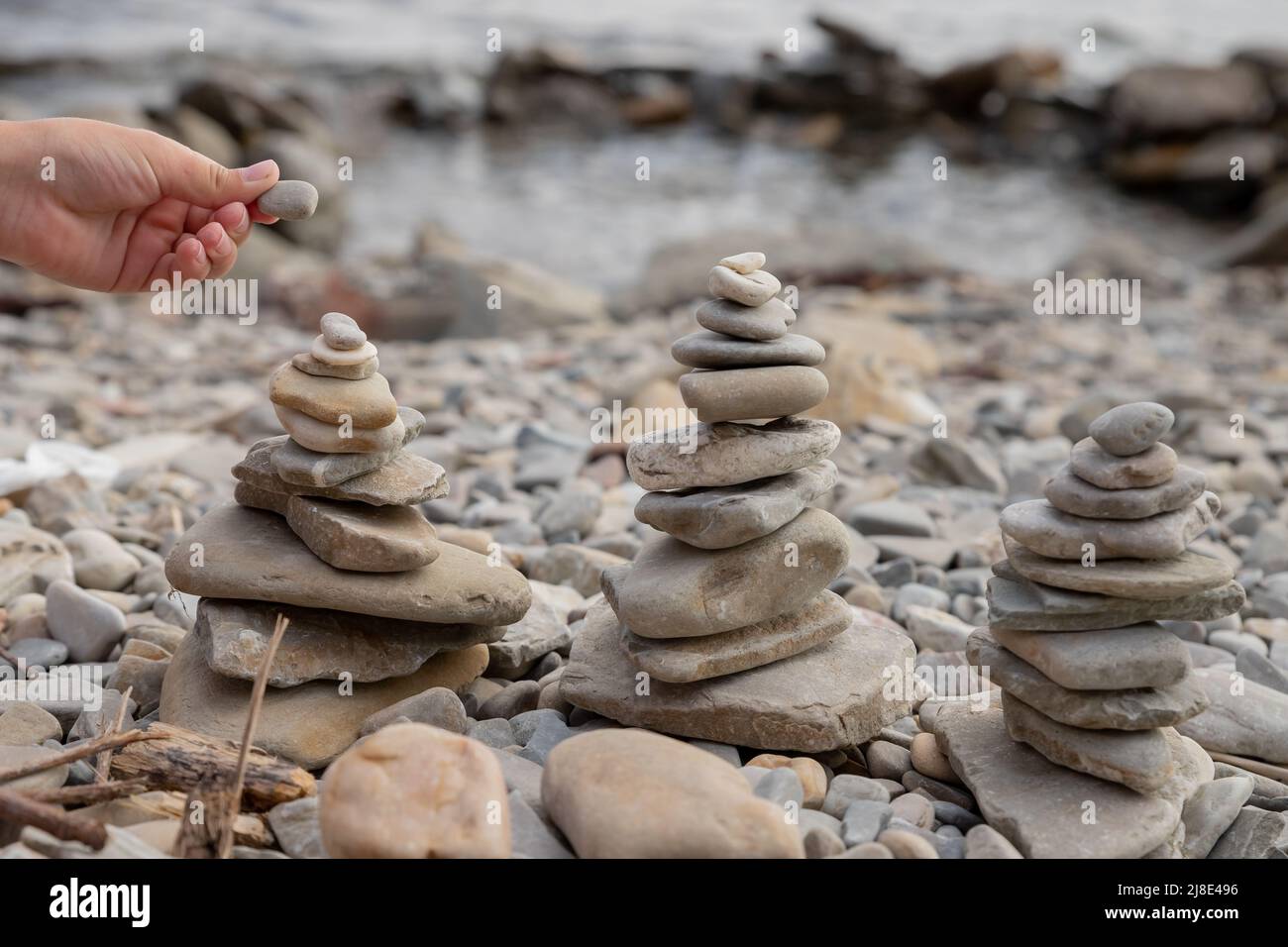 Pyramid of stones on the beach at sunset, beautiful seascape, rest and ...