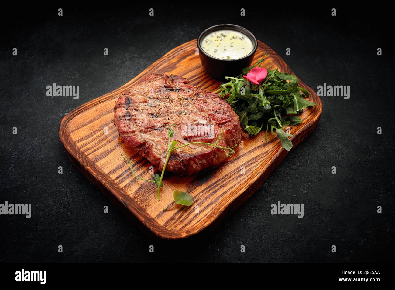 Pork neck steak with sauce and arugula Stock Photo - Alamy