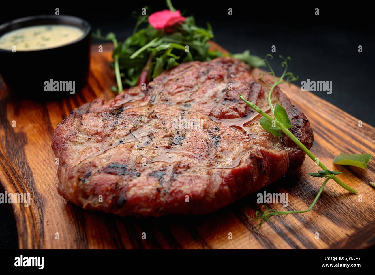 Pork neck steak with sauce and arugula Stock Photo - Alamy