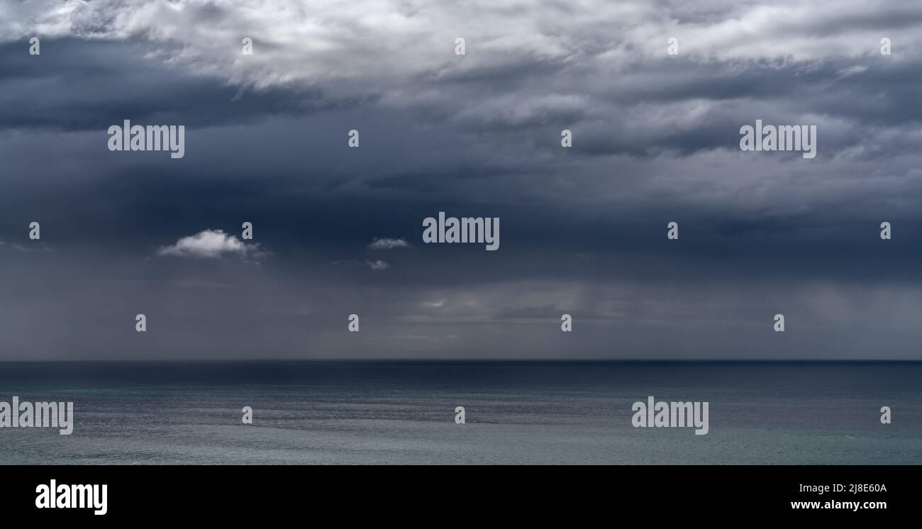 A background of ocean seascape with calm water and stormy overcast sky ...
