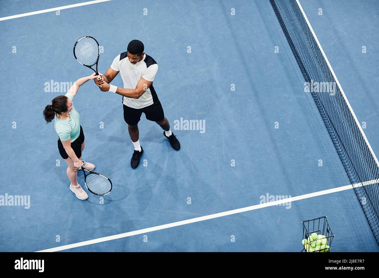 Minimal top view of tennis coach working with client against vibrant ...