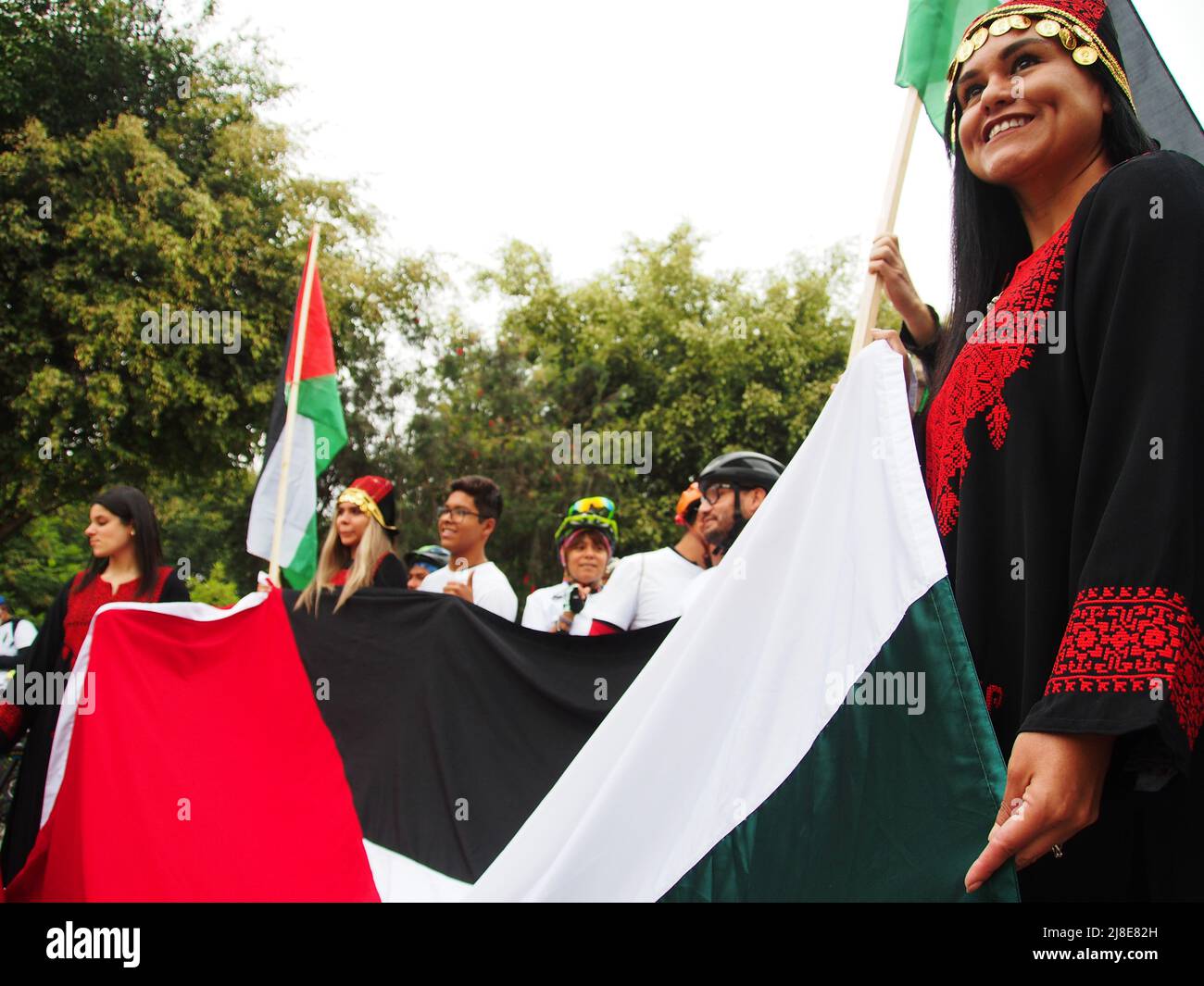 Palestinian girls in traditional dress carrying a flag when thousands ...