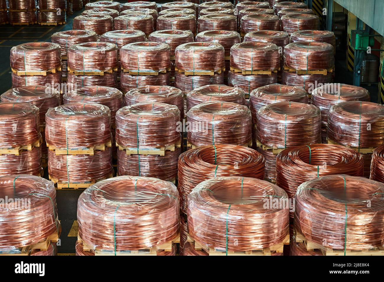 Rows of wrapped copper cable coils in light plant warehouse Stock Photo ...