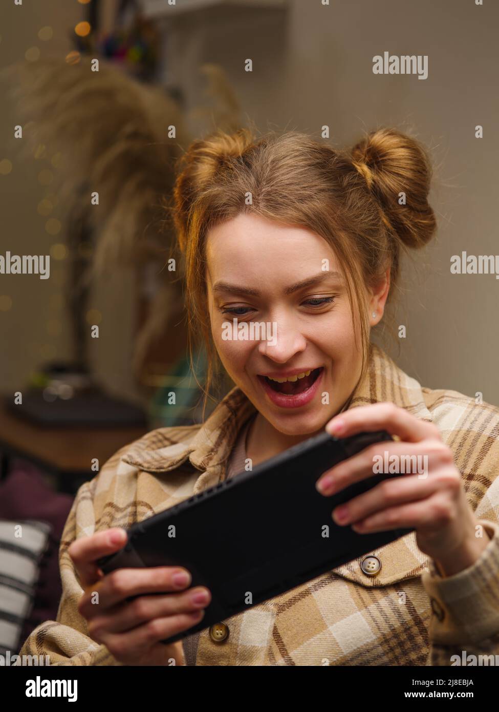 Macro shot. Cheerful girl with a smile rejoices to win the video game ...
