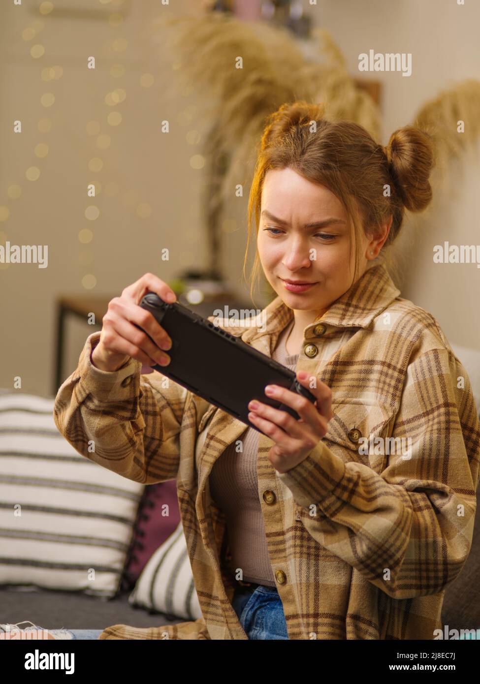 A Cute Girl In Home Clothes Plays A Video Game On A Portable Game 3072