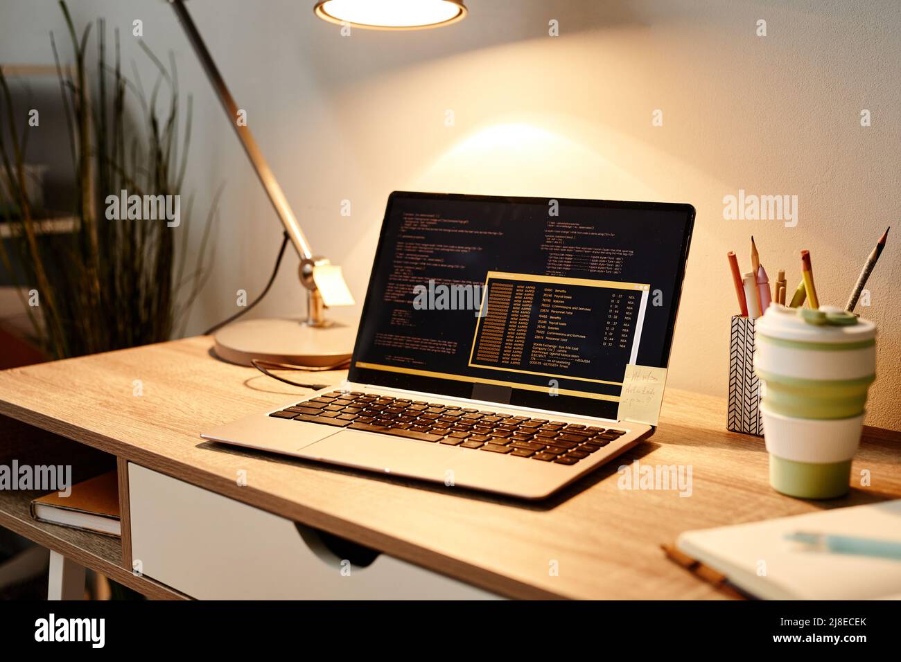 Close up of laptop computer with code on screen at cozy home office ...