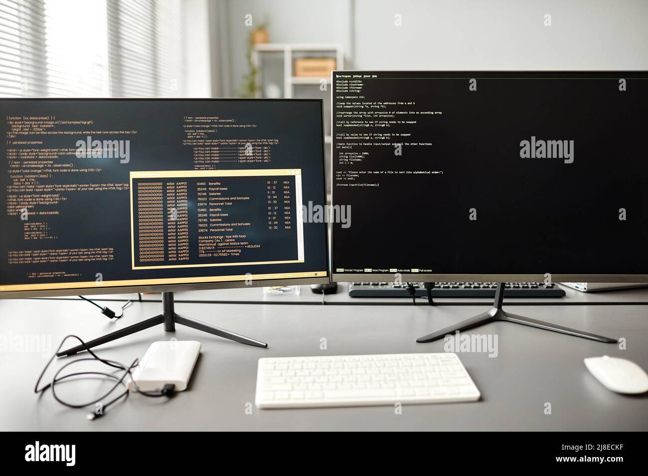 Background image of two computers on desk with code lines on screen in ...