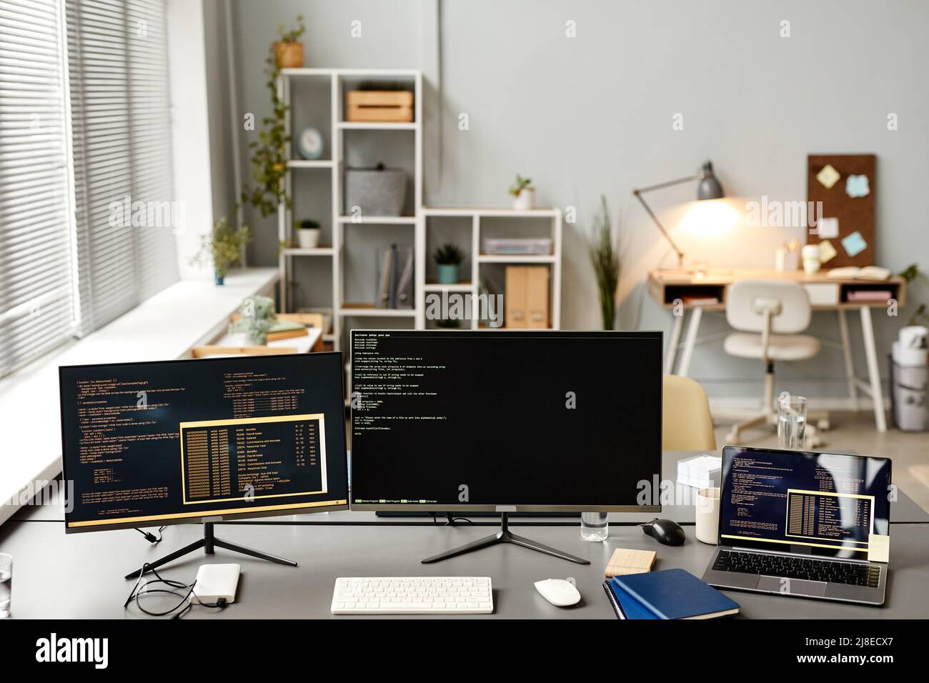 Background image of IT developers office with code on two computer ...