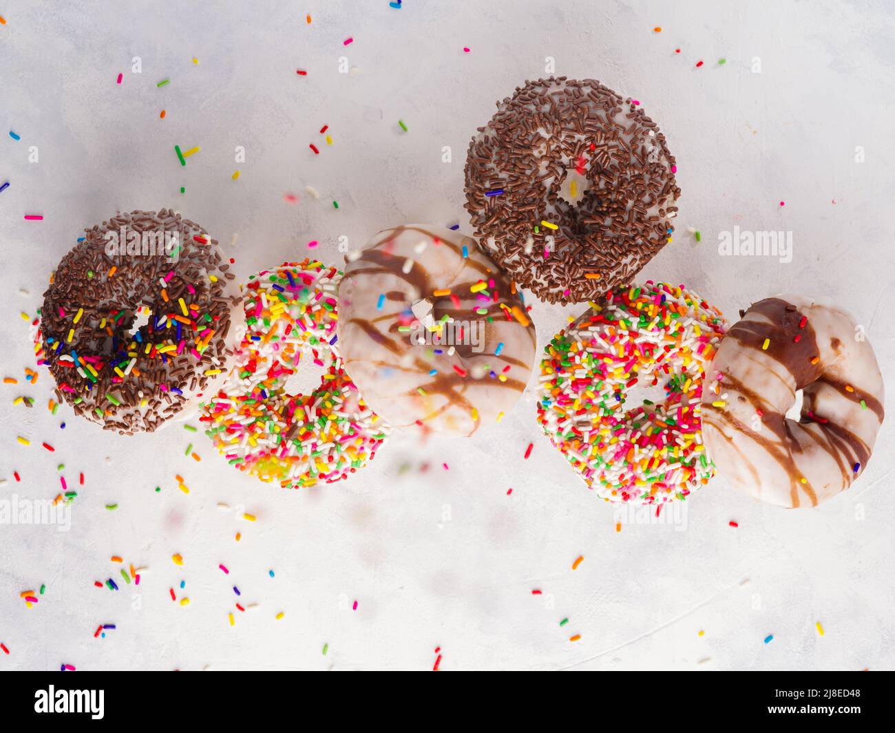 Multi-colored donuts covered with sugar icing, confectionery sprinkles ...