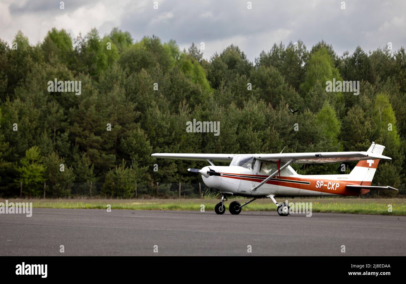 Small plane Cesna 152 staing on the aiifield, sky with clouds, no ...