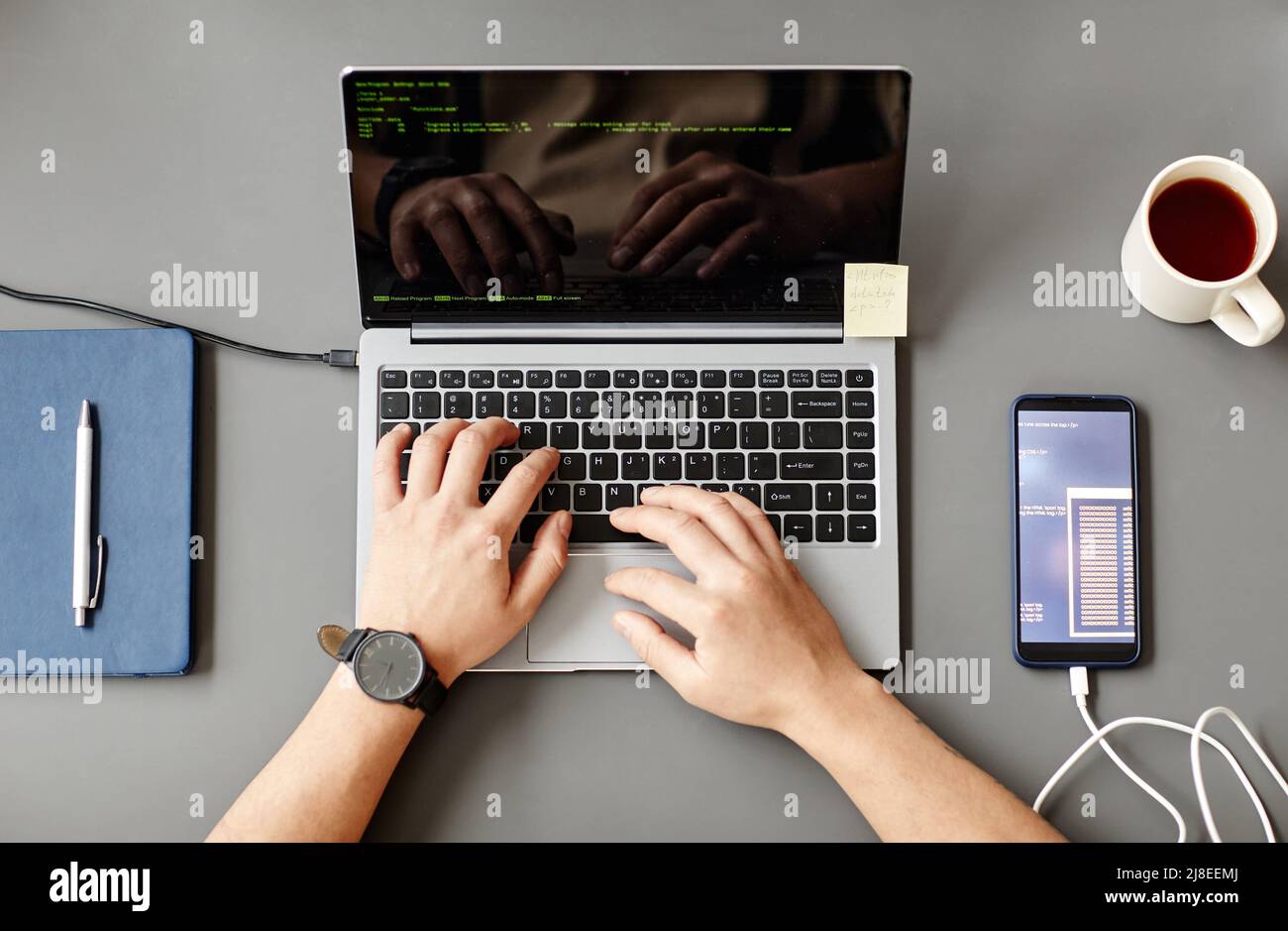Minimal top view of unrecognizable man using laptop and writing code at ...