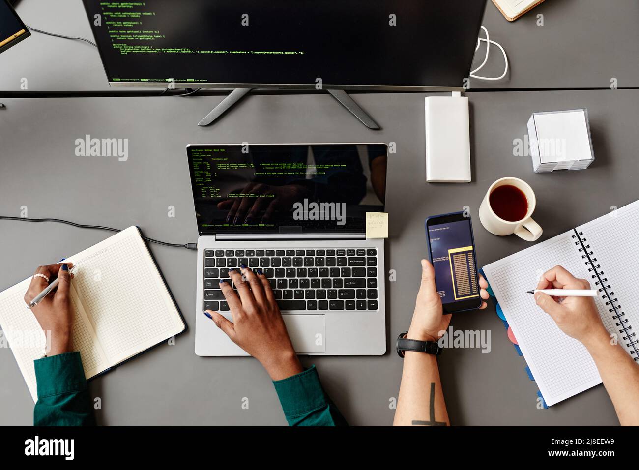 Minimal top view of QA engineers using laptop and reviewing code at ...