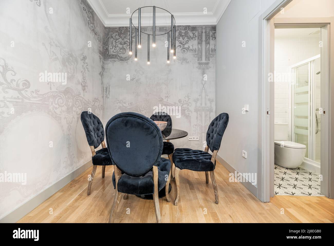 dining room with round glass table, capitone upholstered chairs with ...