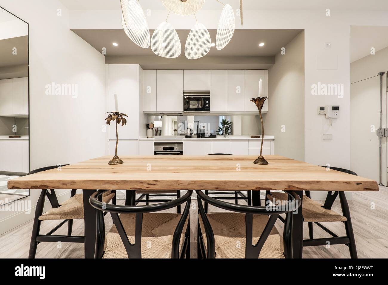 Single plank dining table, black metal matching chairs, mirror on the ...