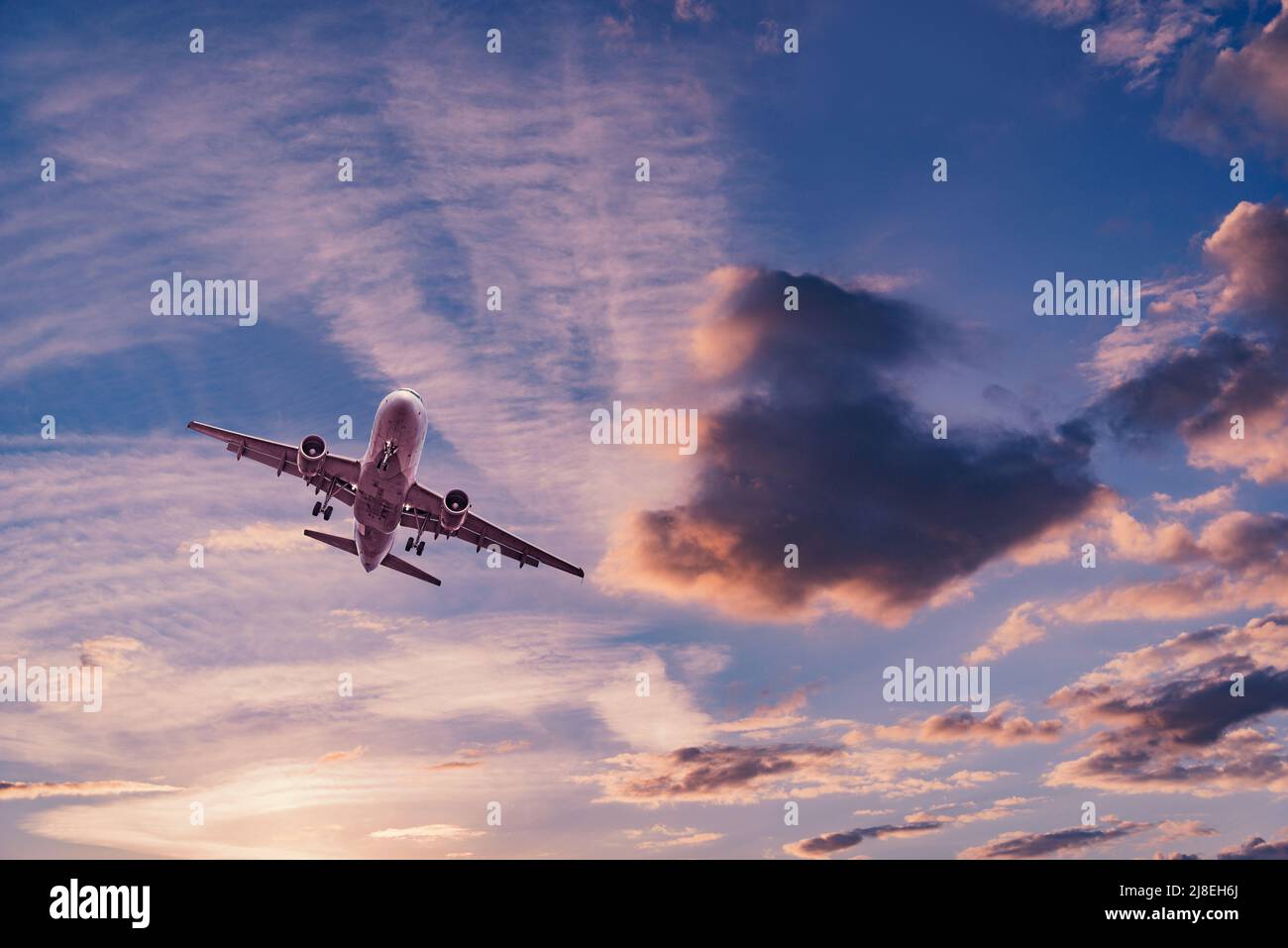 Taking off the passenger plane above the clouds at sunset Stock Photo - Alamy