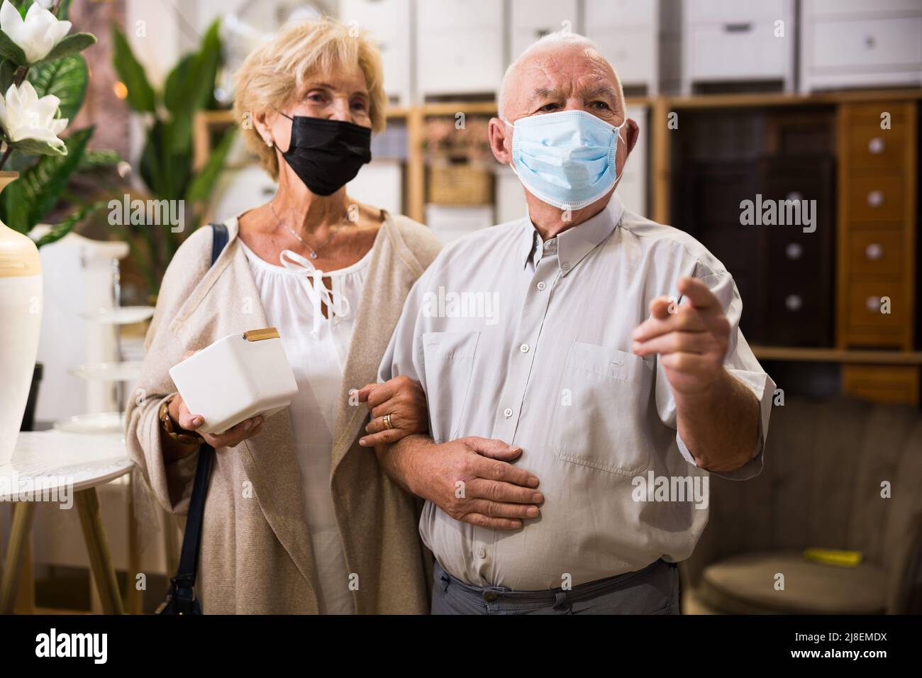 Couple in masks buying goods in the store Stock Photo - Alamy