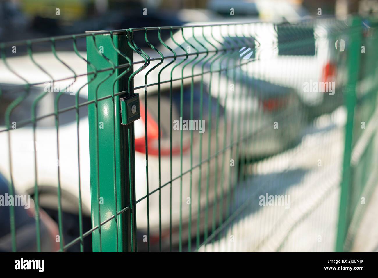 Fence in parking lot. Green fence. Parking area Stock Photo - Alamy