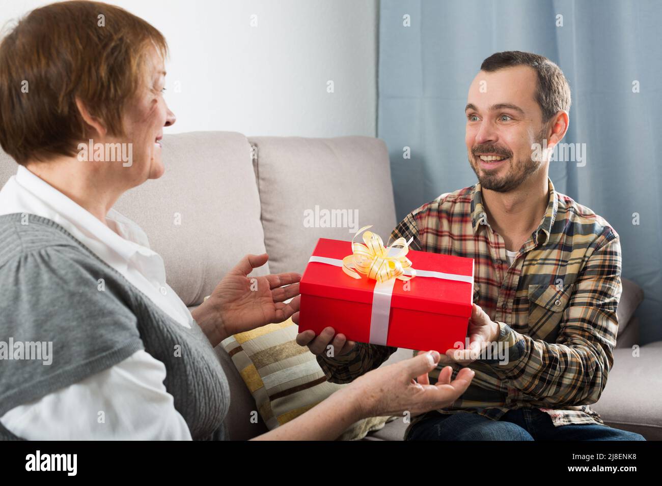 Son giving present to mother Stock Photo - Alamy