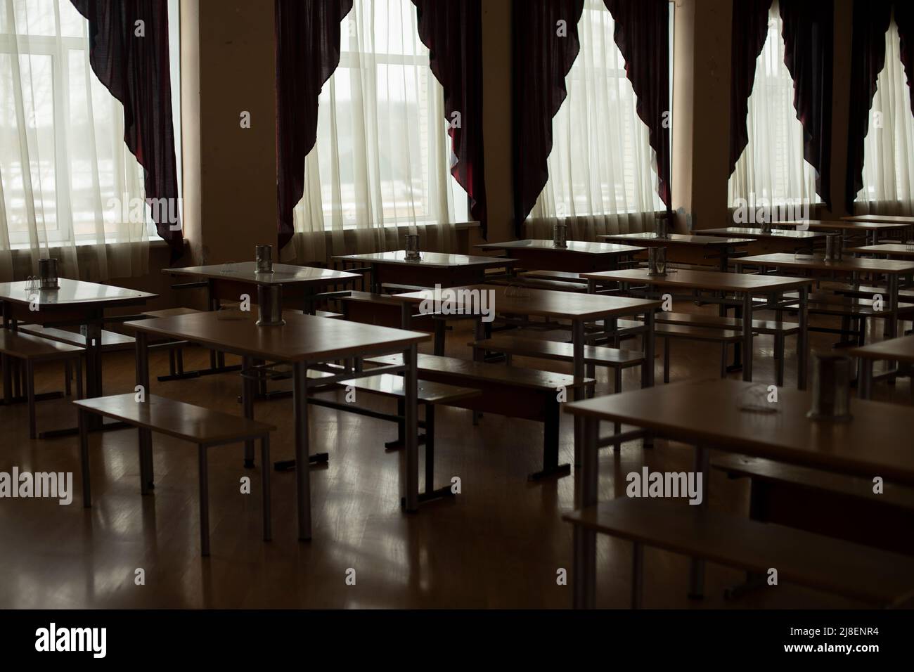 Dark hall with tables. Curtains on window. Canteen in school Stock ...