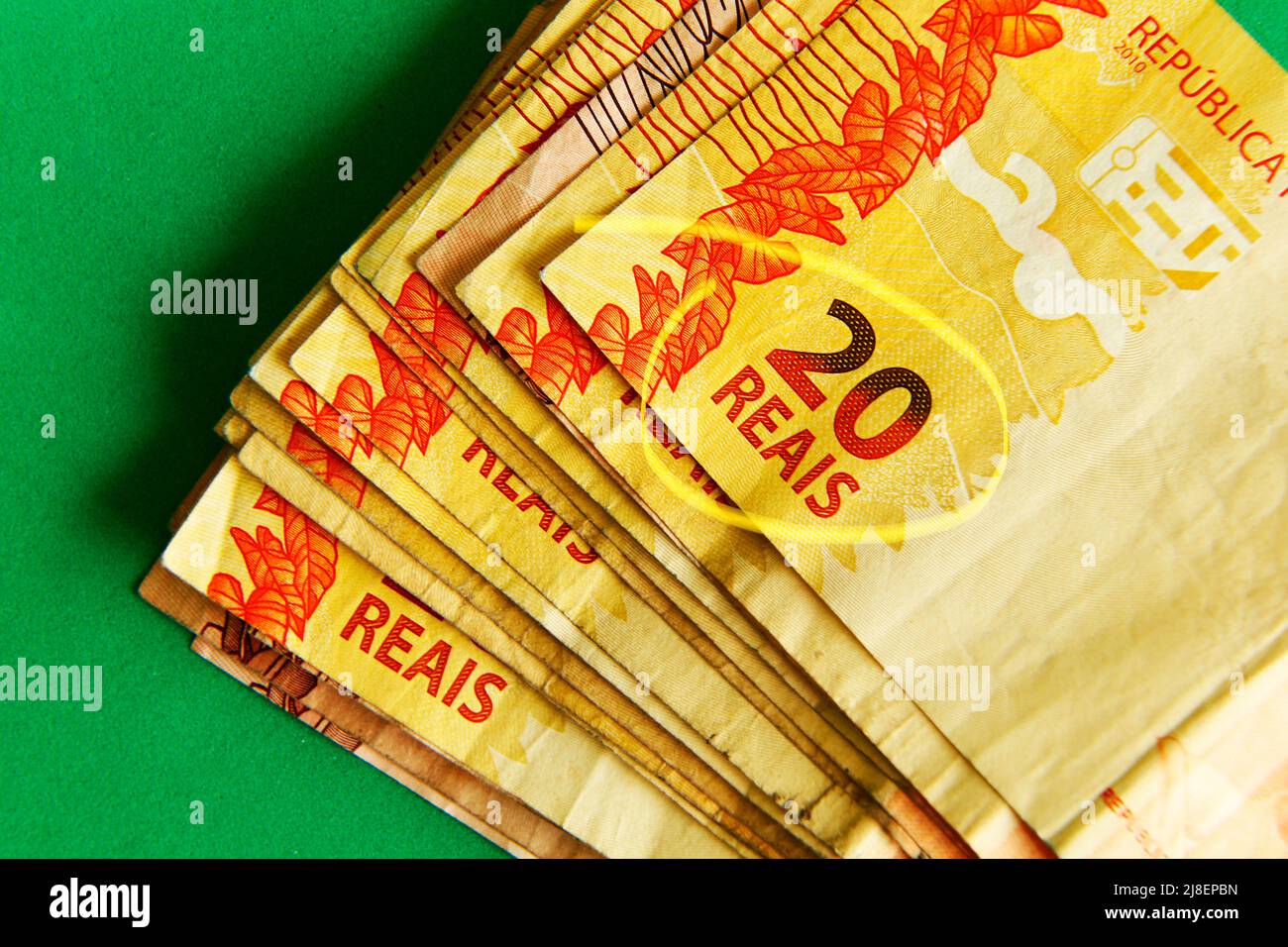 several Brazilian real banknotes lined up on a green table - manual ...
