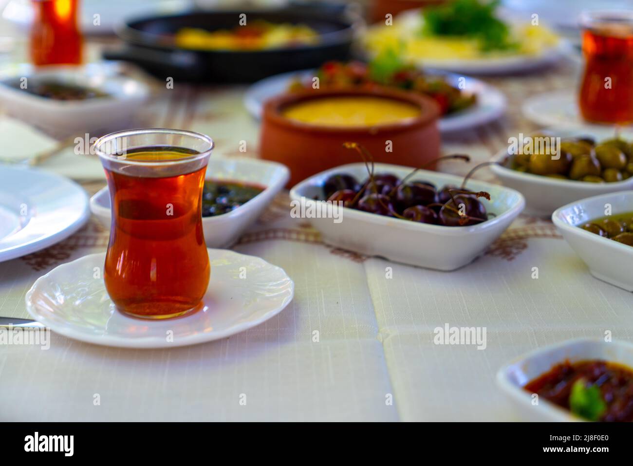 Breakfast stands on the table with a white floor cloth; tea olive ...