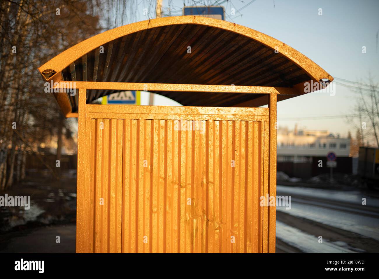 Yellow bus stop. Steel structure by road. Place of transport stop in ...