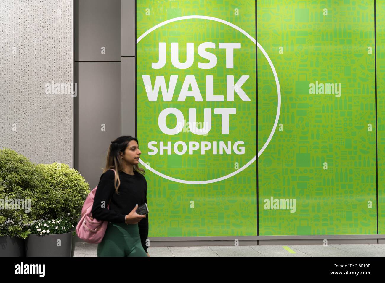 women shopper outside the amazon grocery shop "amazon just walk out shopping" sign London ...