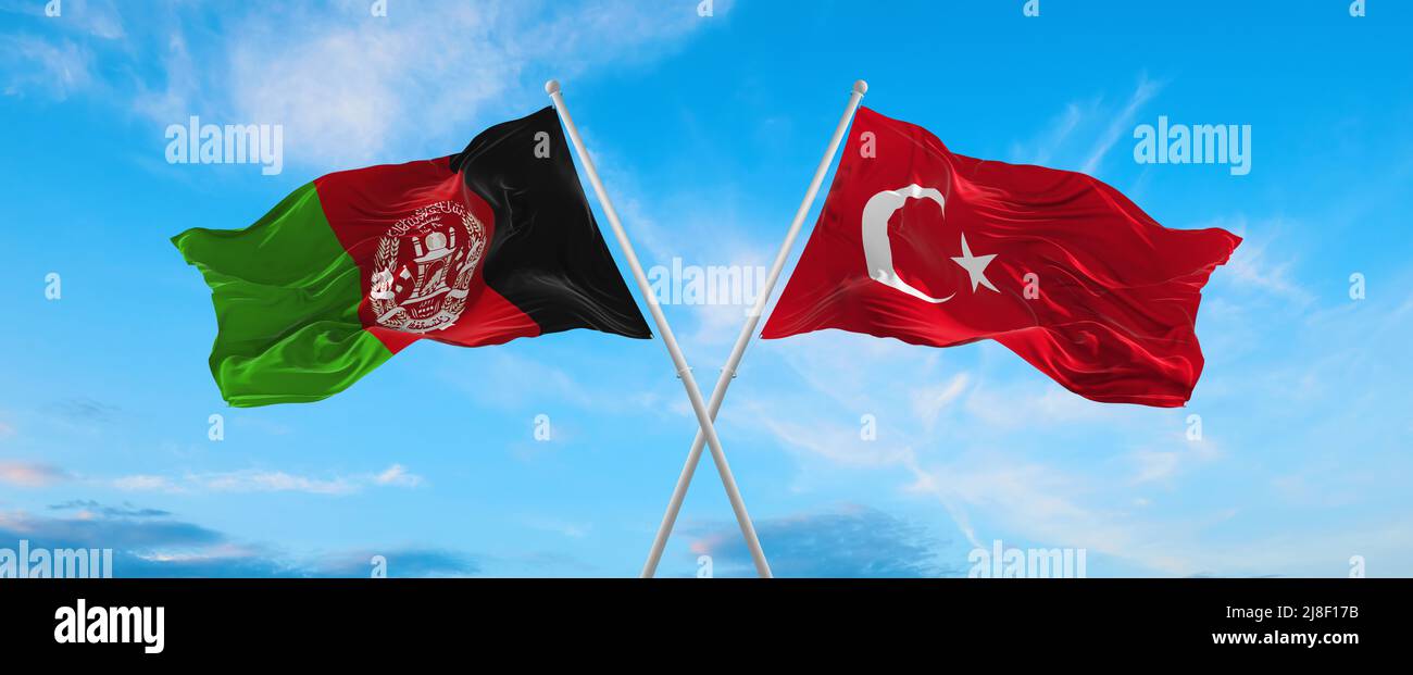two crossed flags Afghanistan and Turkey waving in wind at cloudy sky. Concept of relationship ...