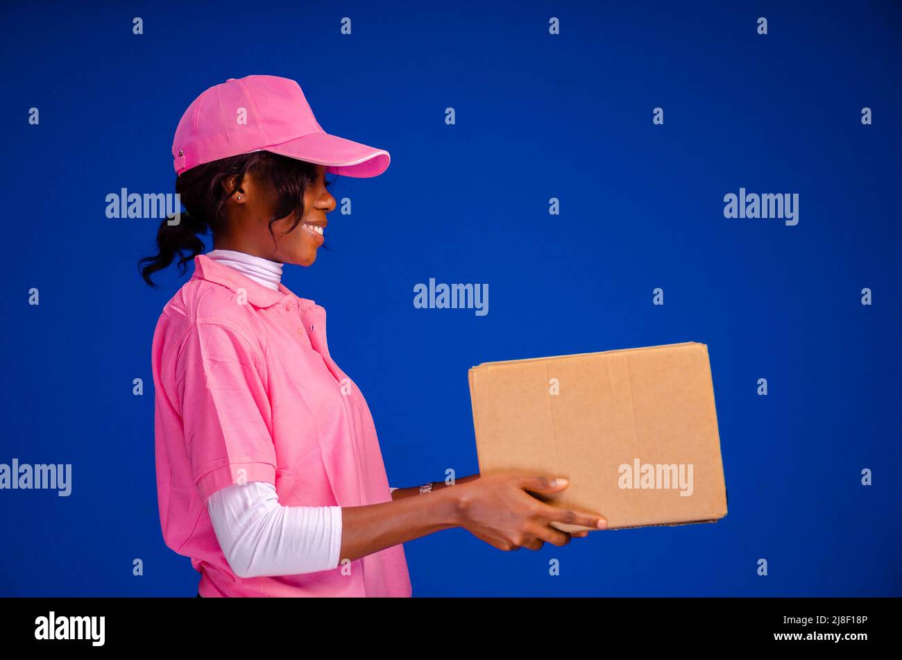 beautiful african delivery woman holding a package Stock Photo - Alamy