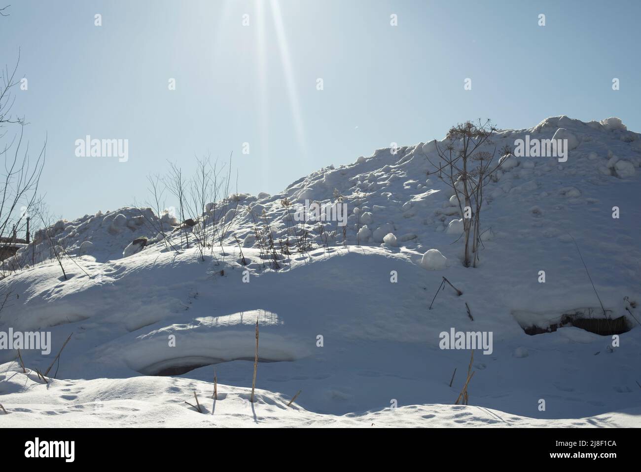 Mountain of snow in sunlight. Rays in snow. Large snowdrift in winter ...