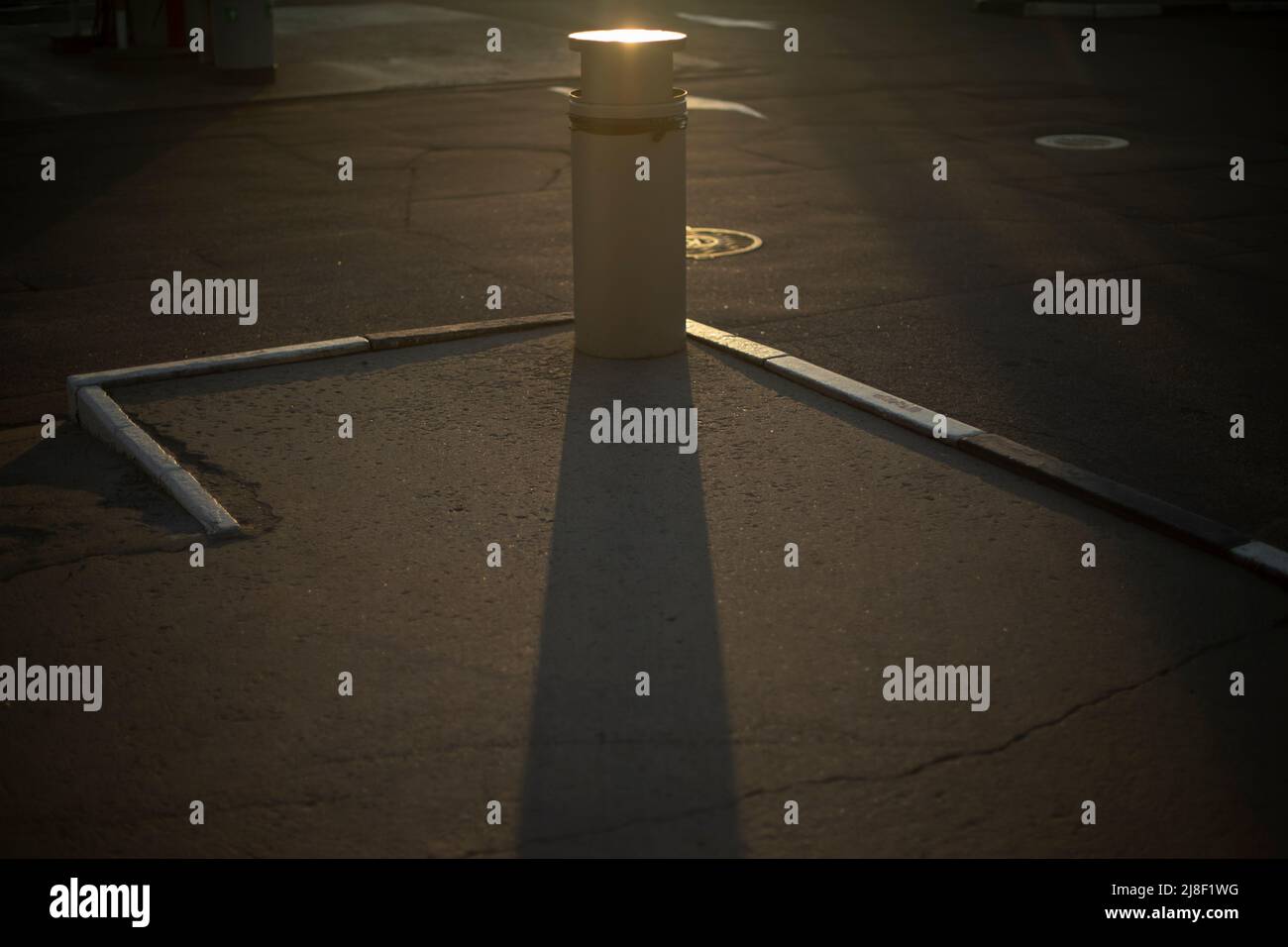 Urn in parking lot. Place to collect garbage on street. Shade from ...
