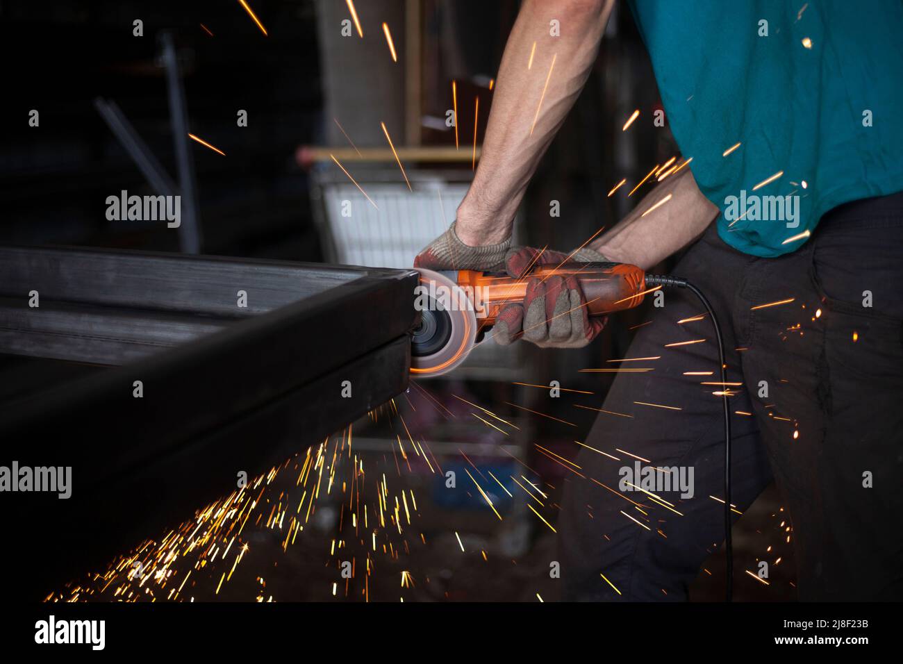 Work with a grinder for metal. Sparks from metal friction. A worker is ...