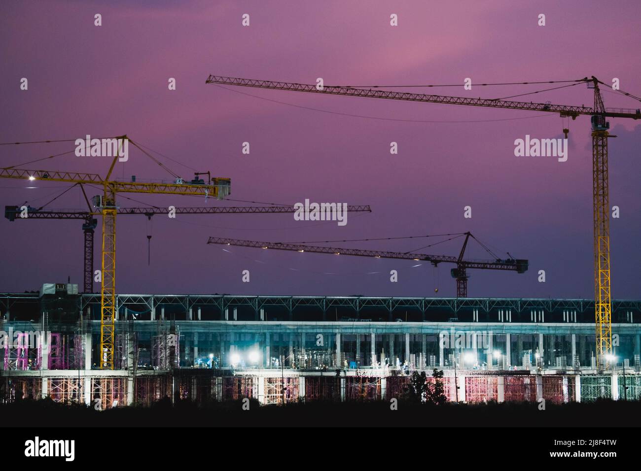 A large construction site with busy cranes. Tower cranes working on a ...