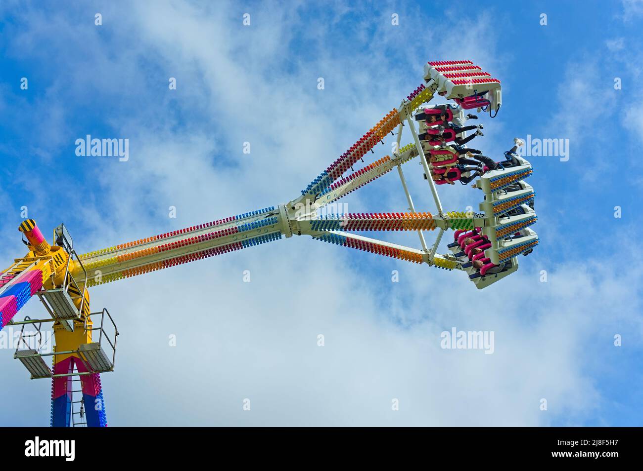 Children riding high on an exciting amusement ride at the fun fair with ...