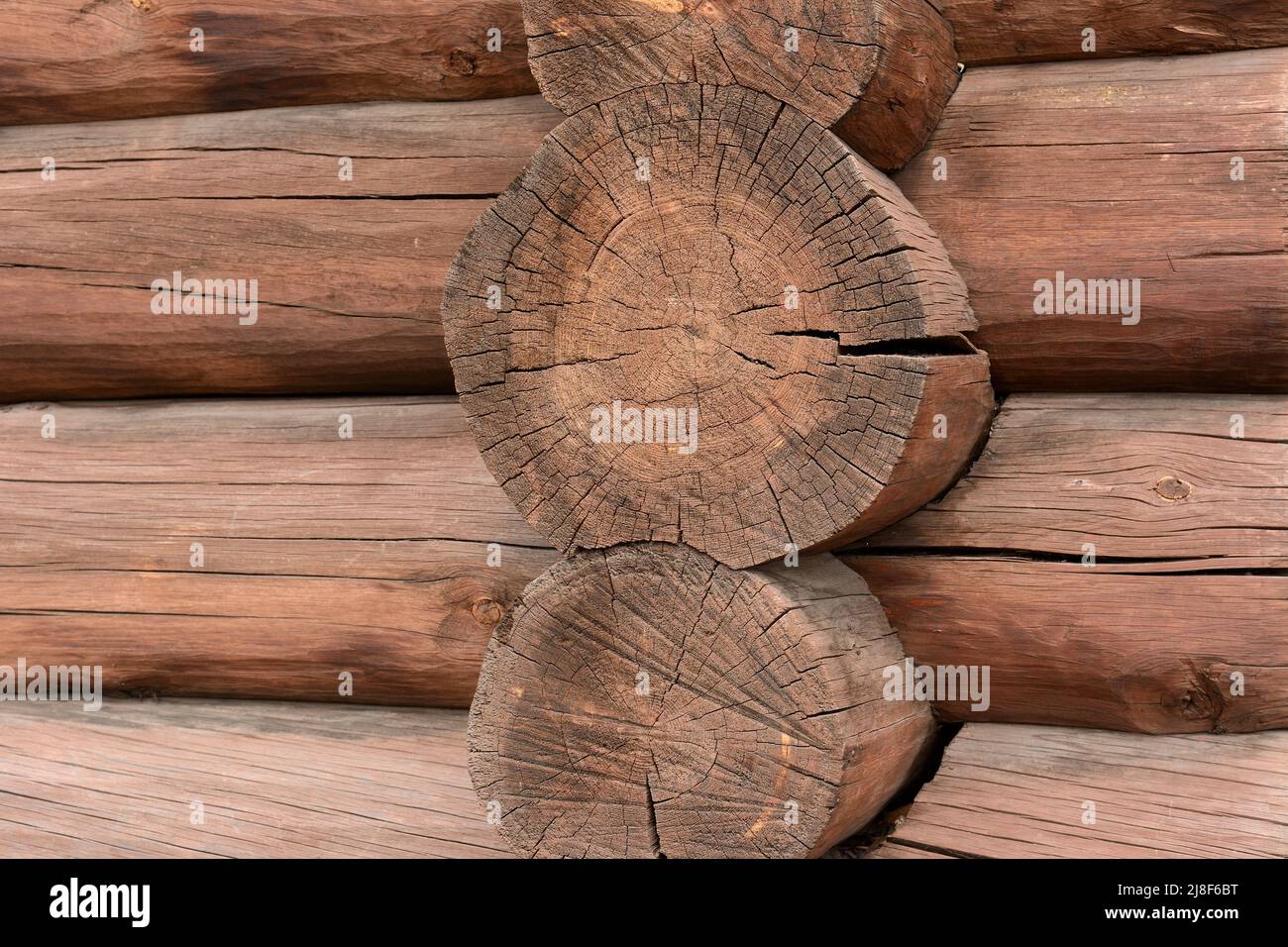 A fragment of a wall assembled from rounded timber and antique-painted ...
