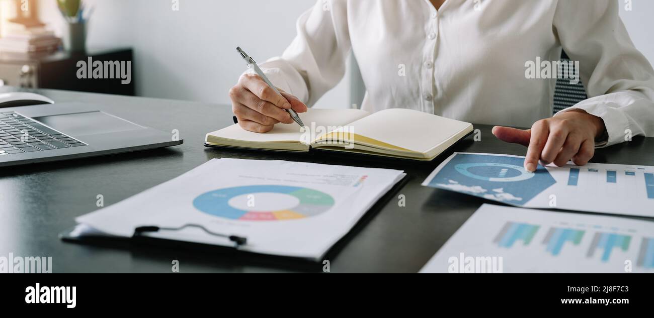 Accountant working on desk in office using calculator and laptop to ...
