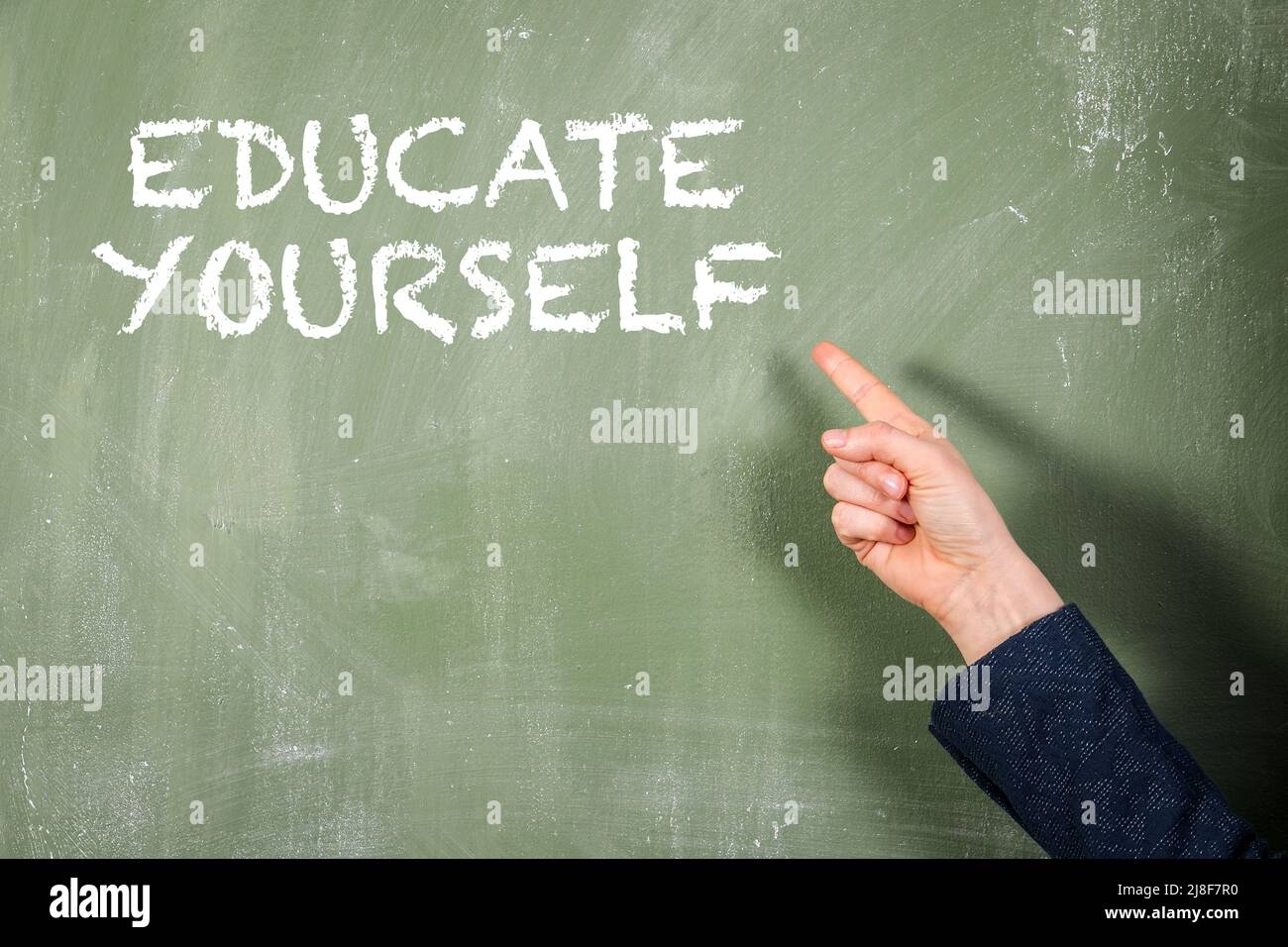 Educate Yourself. Woman points finger at text. Green chalk board Stock ...