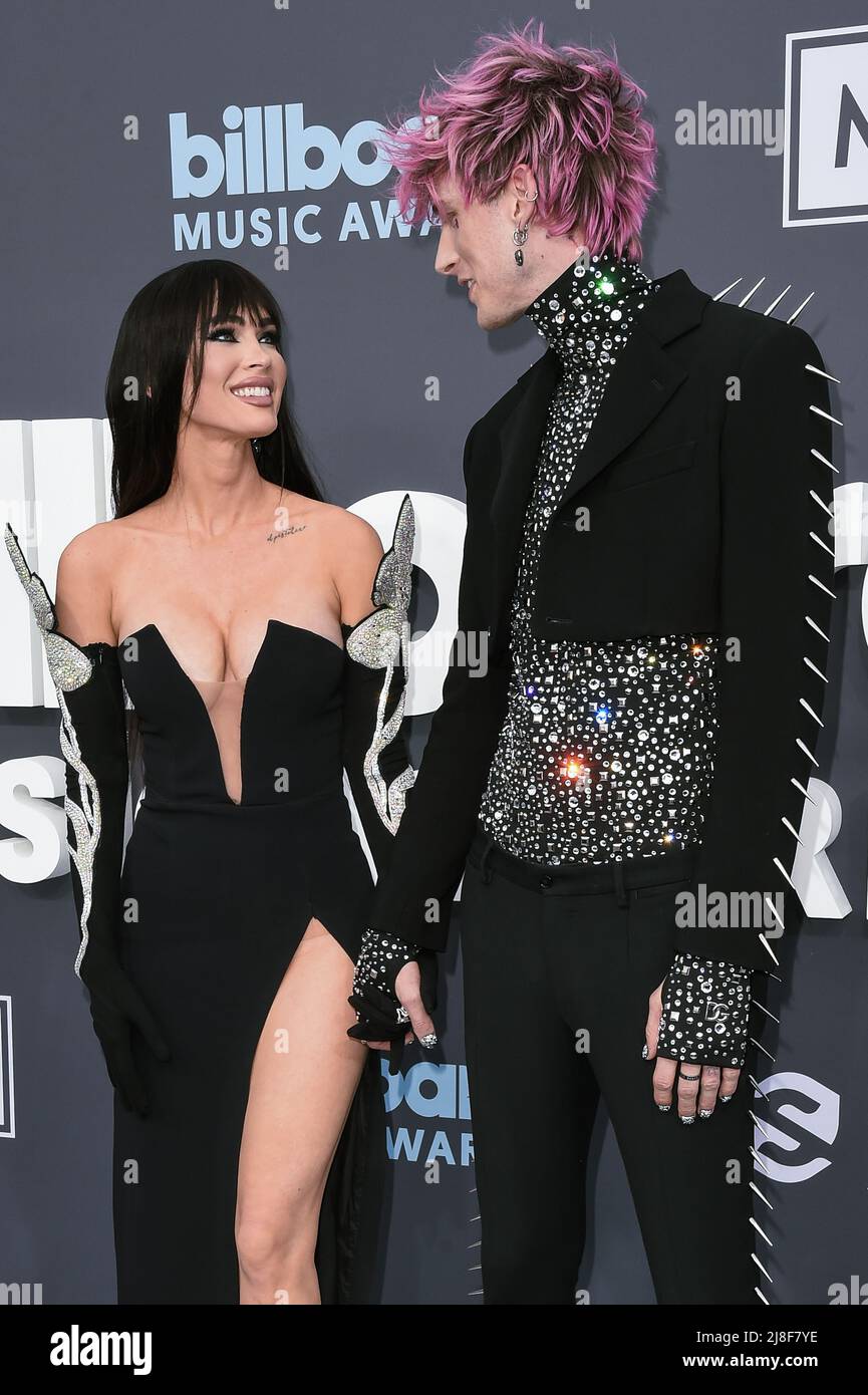 Megan Fox and Machine Gun Kelly walking on the red carpet at the 2022 Billboard Music Awards at ...