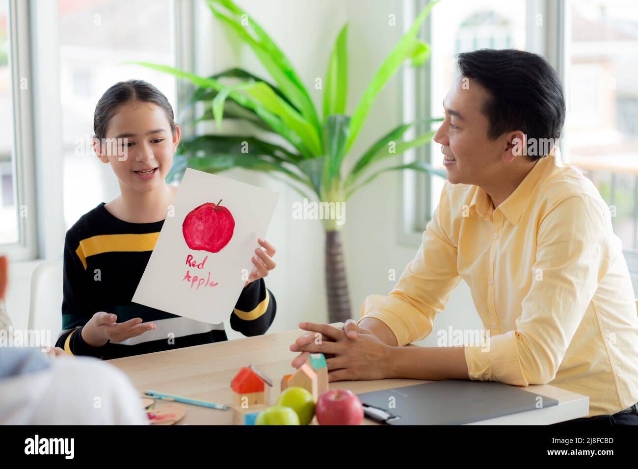 Student girl showing drawing watercolor with teacher and friends and ...