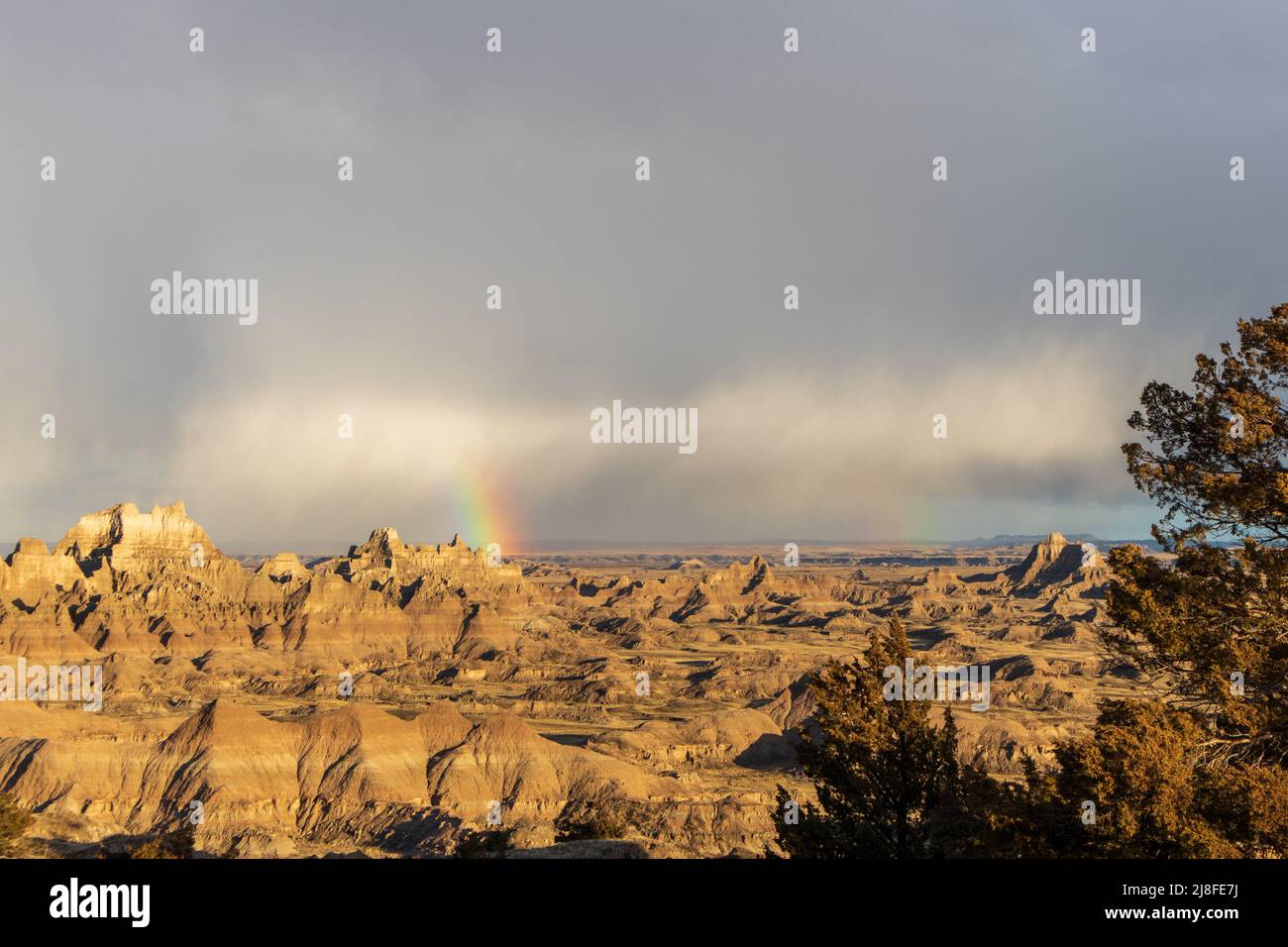 A rainbow is visible behind the landscape at Badlands National Park in ...