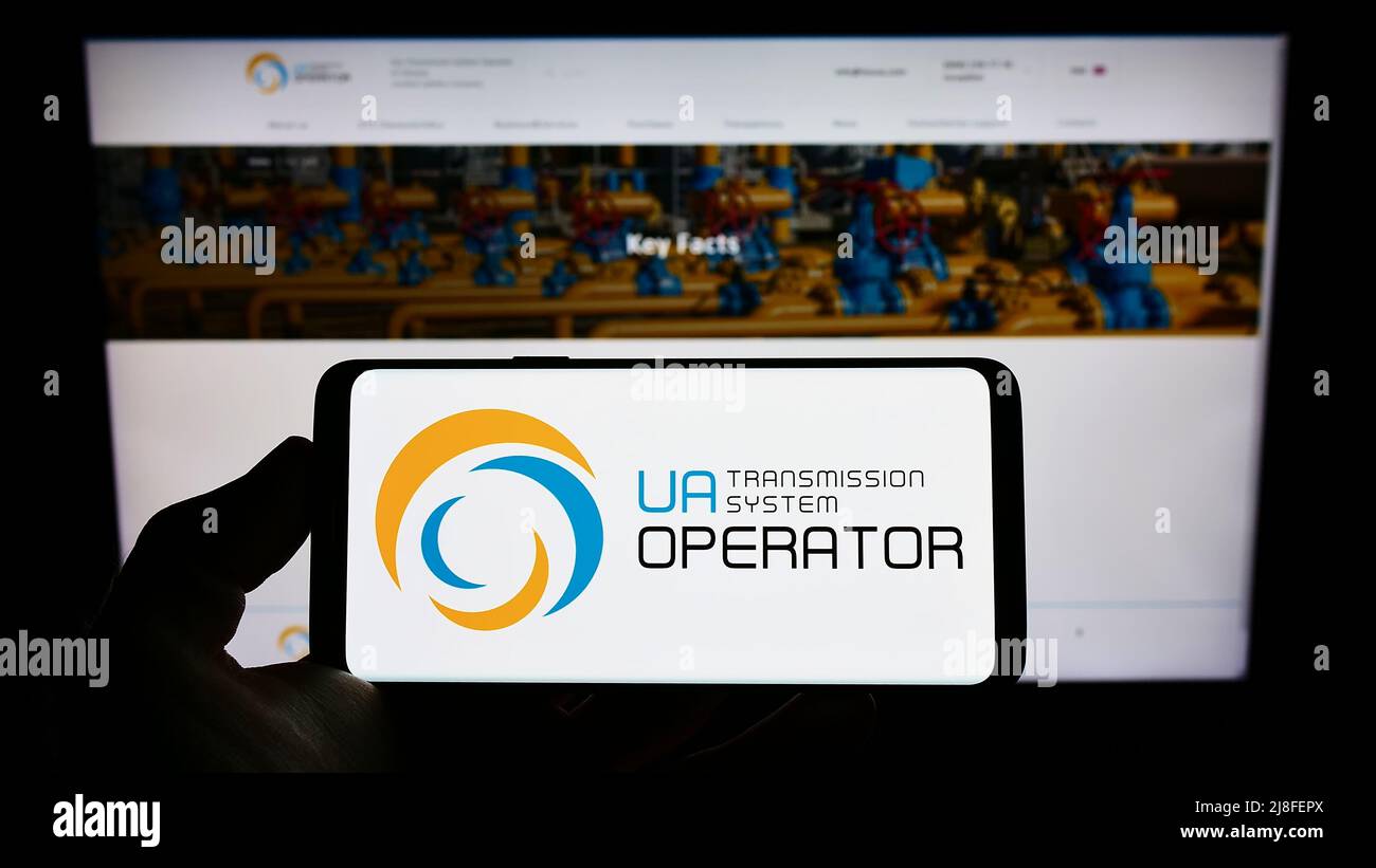 Person holding mobile phone with logo of Gas Transmission System ...