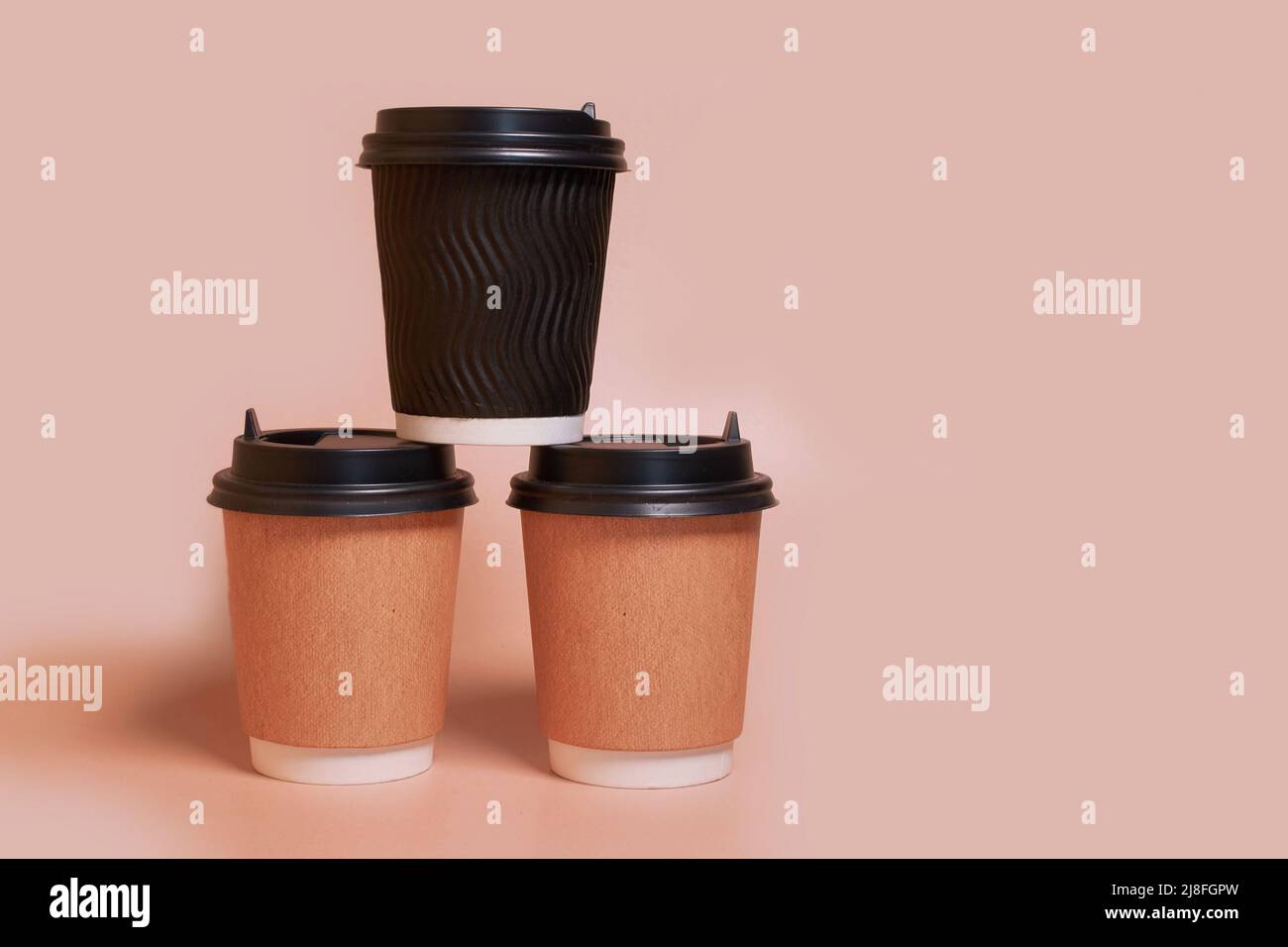 Mockup. Three paper coffee cups on a colored background Stock Photo - Alamy