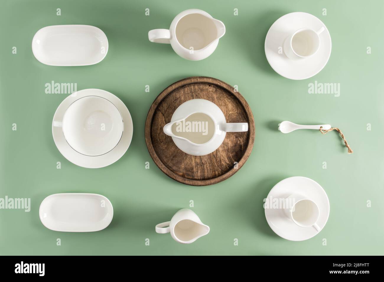white ceramic and porcelain cups, saucers, milk jug of different shapes ...
