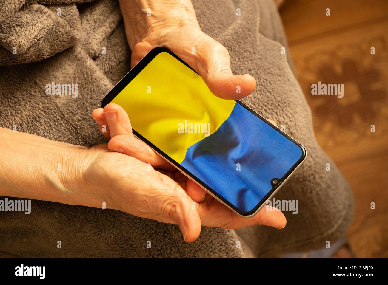 The national flag of Ukraine as a background on the phone in the hands ...