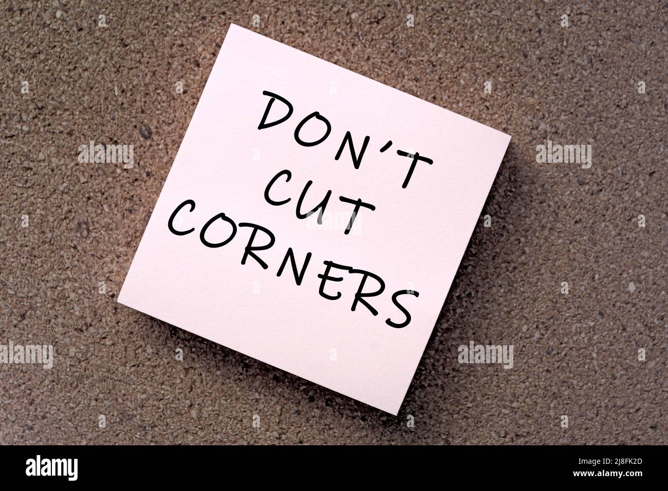 Don't cut corners message on sticky note against brown paper Stock ...