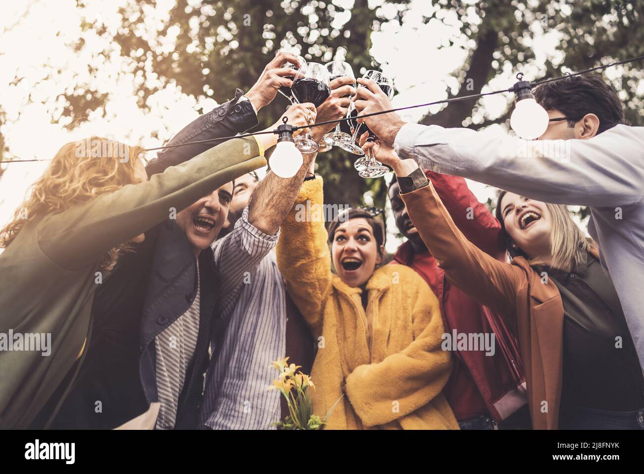 A group of friends of different ethnic backgrounds meet at sunset in ...