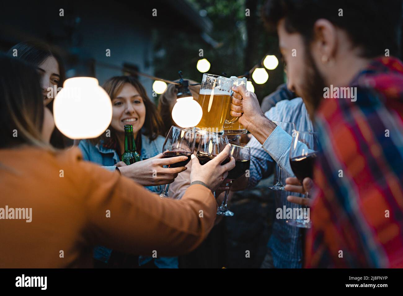 a lively group of friends toasting in the terrace of the restaurant pub ...